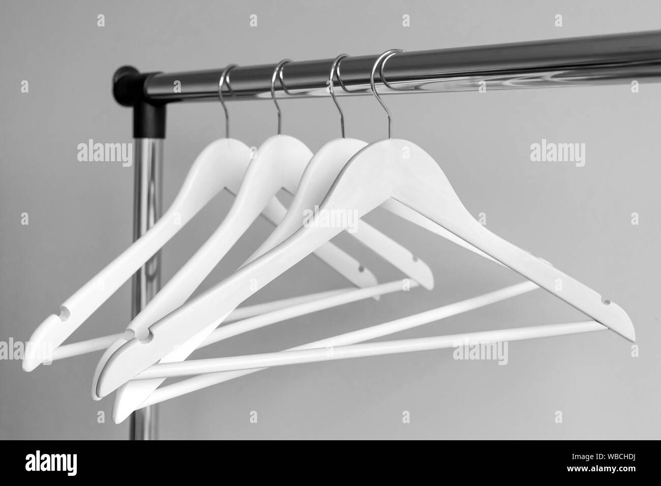 Empty clothes hangers on metal rail against grey background ...
