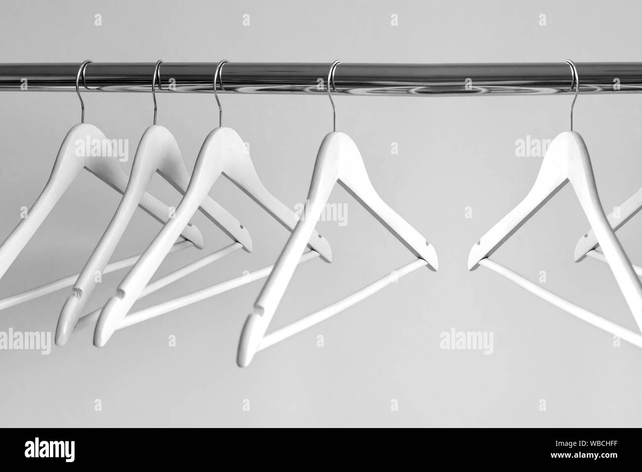 Empty clothes hangers on metal rail against grey background ...