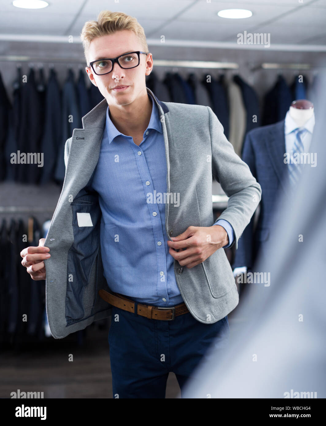 Man costumer in the glasses trying business style jacket in the shop ...