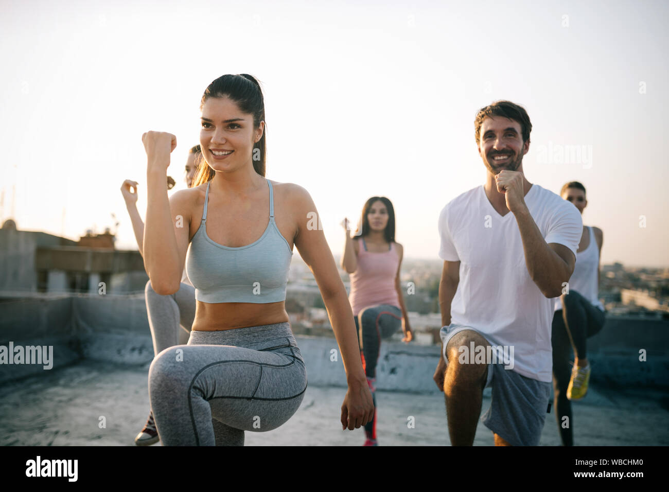 Group of friends fitness training together outdoors living active ...