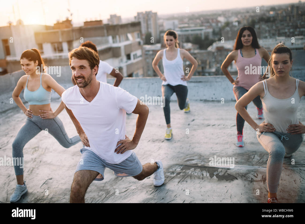 Group of fit healthy friends, people exercising together outdoor on ...