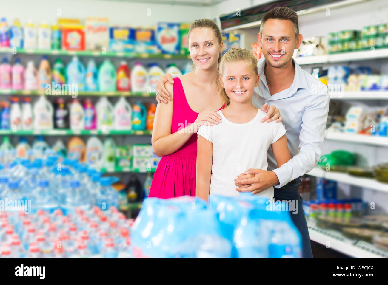 Happy young people showing clean water in bottle in food shop Stock ...