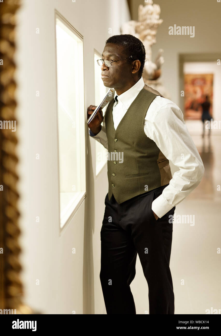 African man looking at exhibit on exposition of historical museum Stock ...