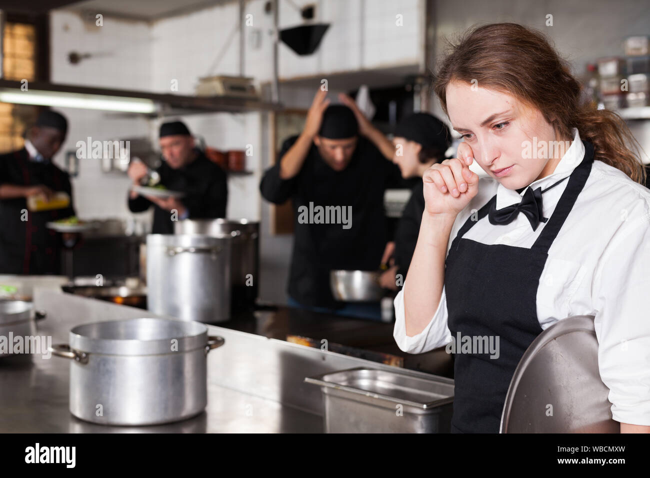 Tired and upset waitress in kitchen of restaurant Stock Photo - Alamy