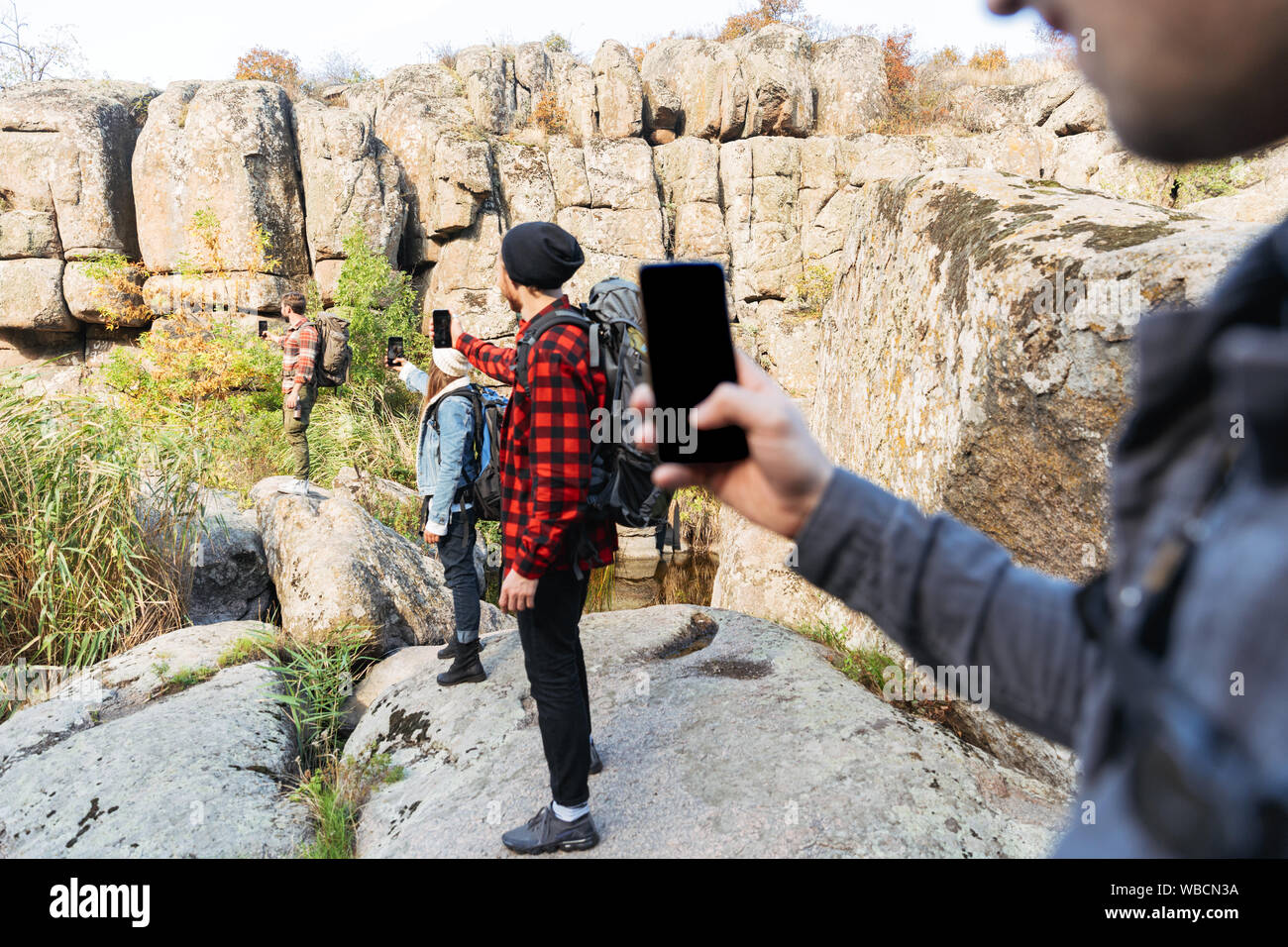 Group of young happy friends carrying backpacks on a hike together ...