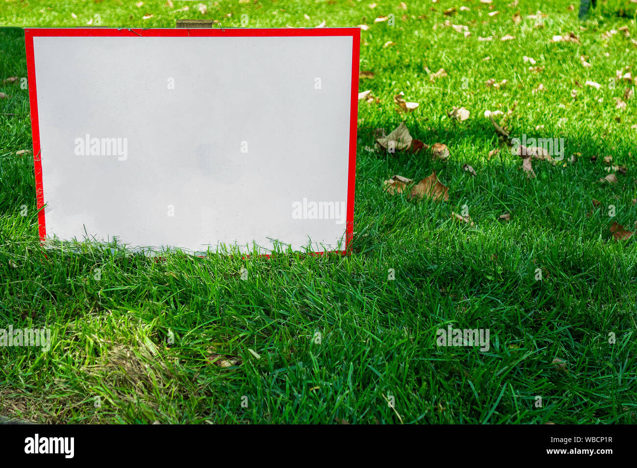 Warning table with copy space in green grass. Mock up for park or ...