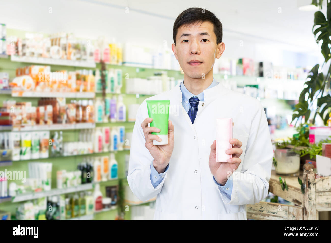 Portrait of japanese male pharmacist who is holding medicines near ...