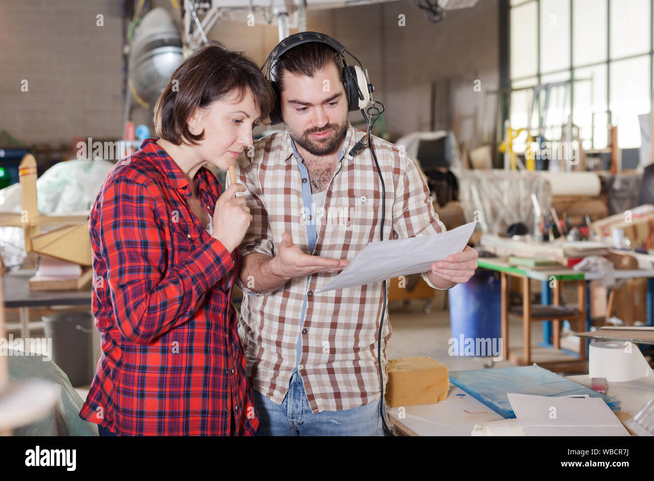 Team of aircraft enthusiasts working in workshop on creating of ...