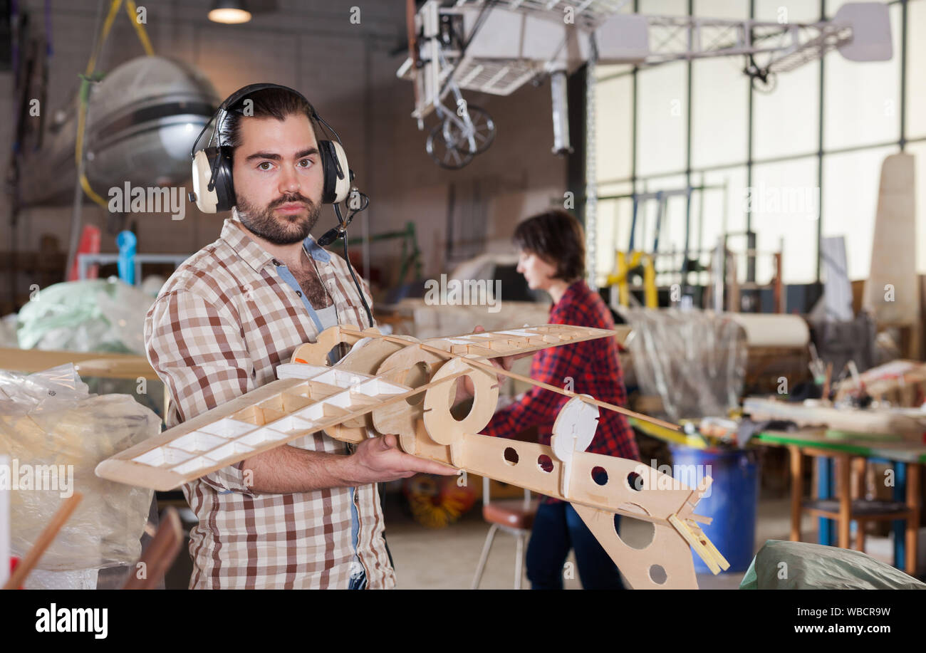 Young male hobbyist engaged in creating plane models in aircraft ...