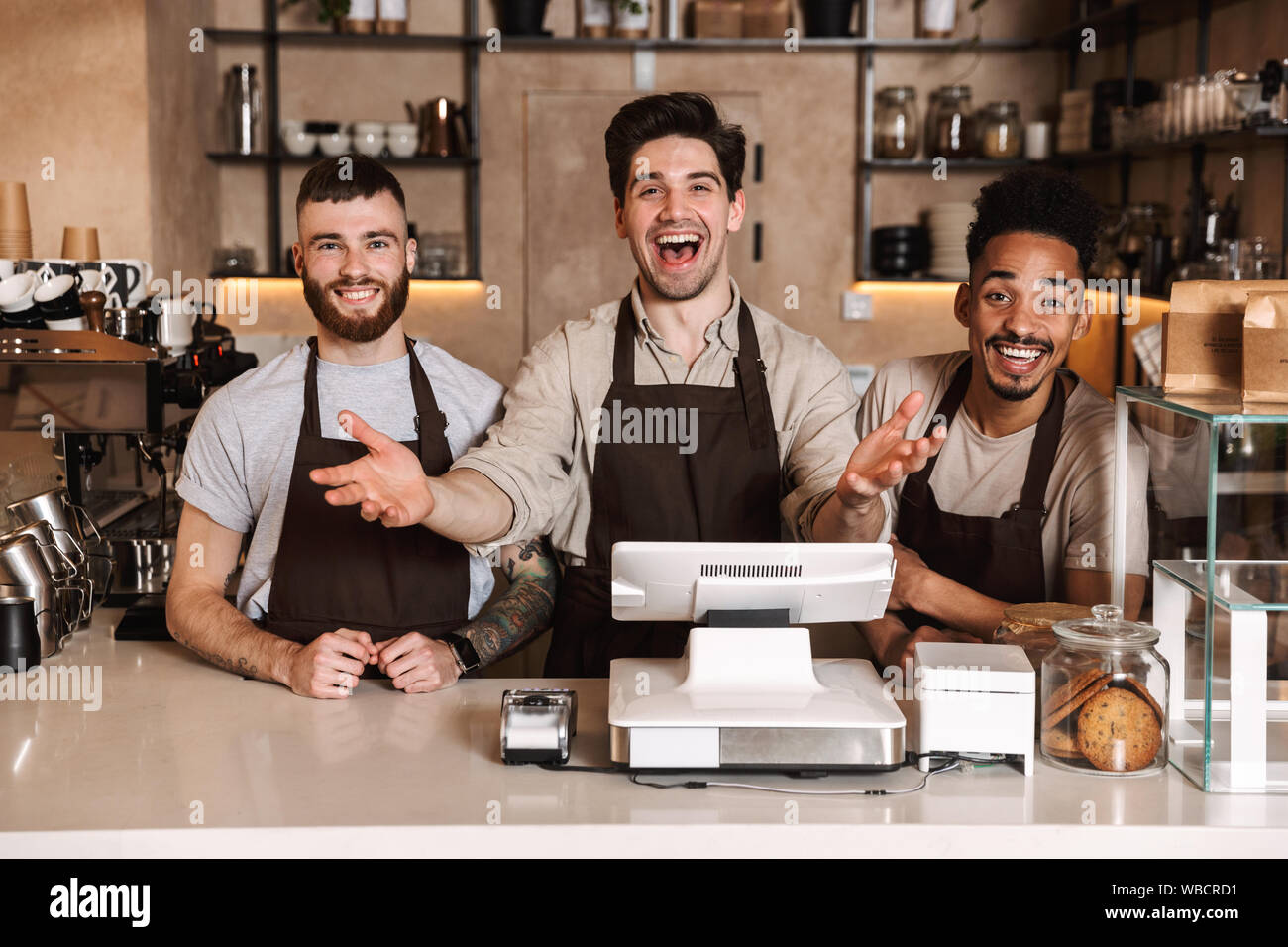 Image of three happy coffee men colleagues in cafe bar working indoors ...