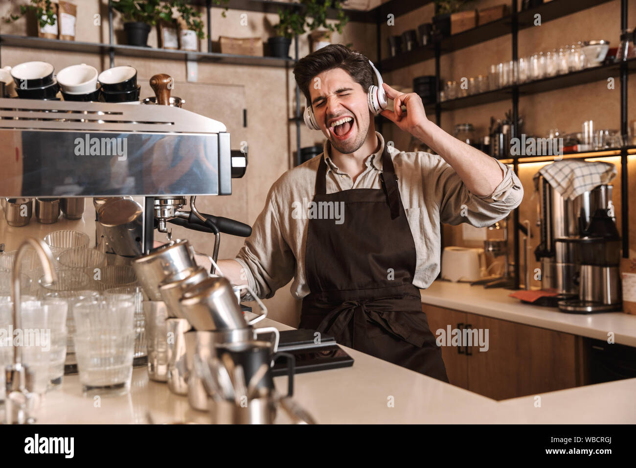 Image of handsome happy coffee man posing in cafe bar working indoors ...