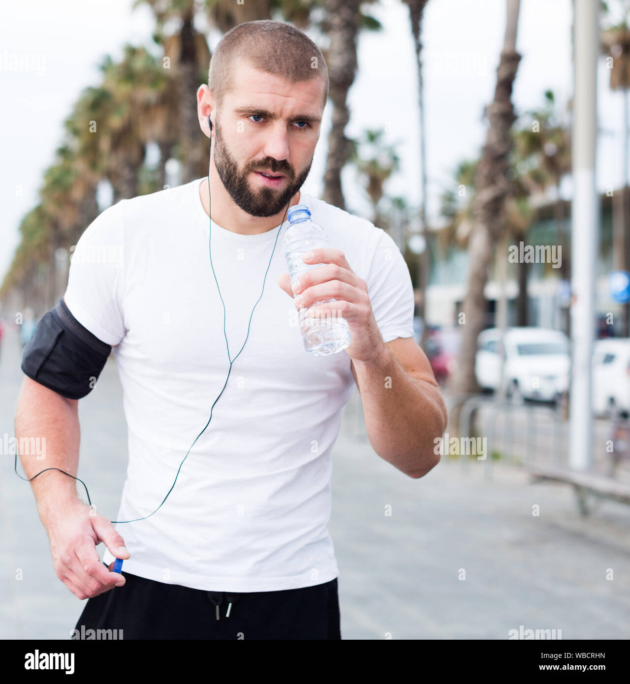 Athletic male stopped to rest while running Stock Photo - Alamy