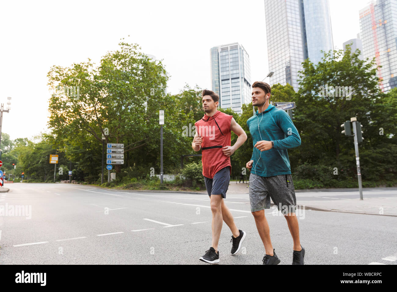 Photo of two athletic young men wearing sportswear doing workout and ...