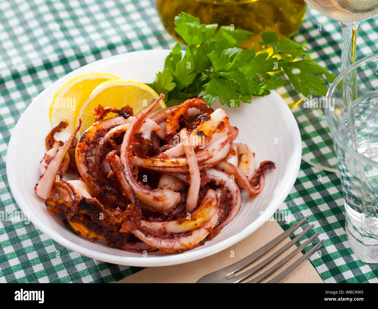 Deep fried crispy squid tentacles served with fresh lemon and greens ...