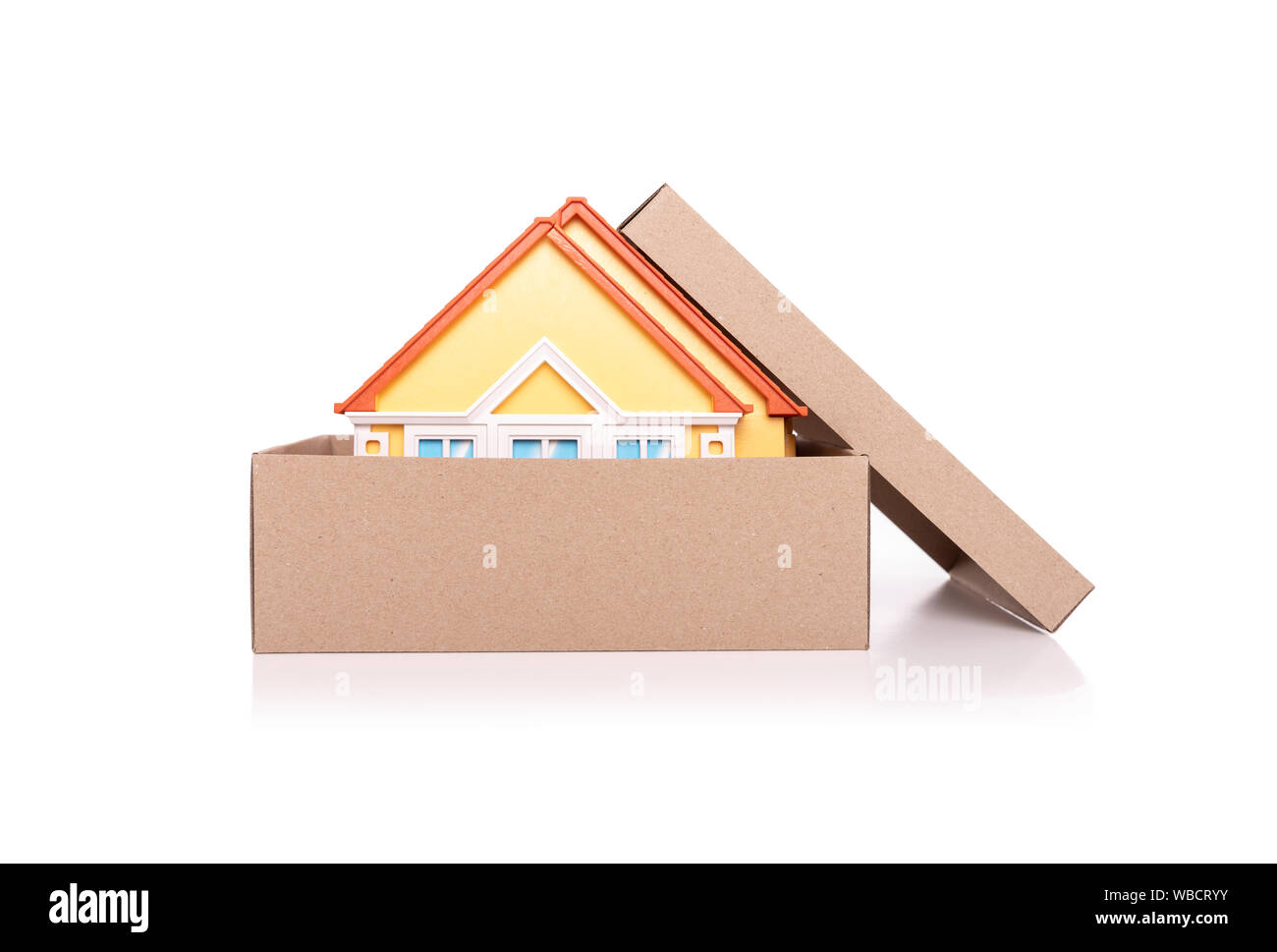 Toy model of a house in a cardboard box on white background Stock Photo ...