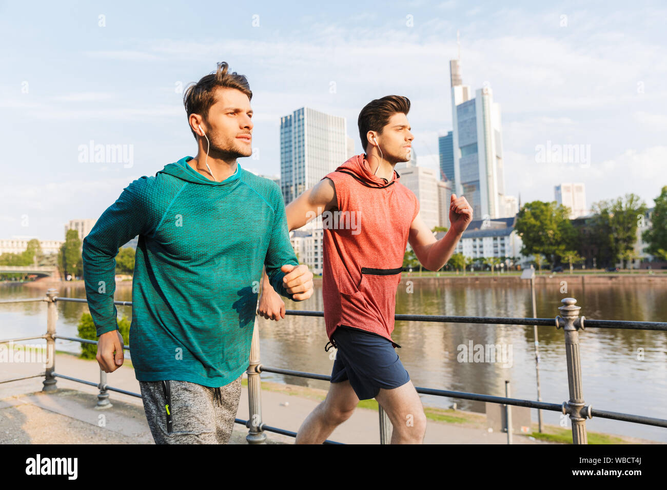 Photo of two strong handsome men wearing sportswear doing workout and ...