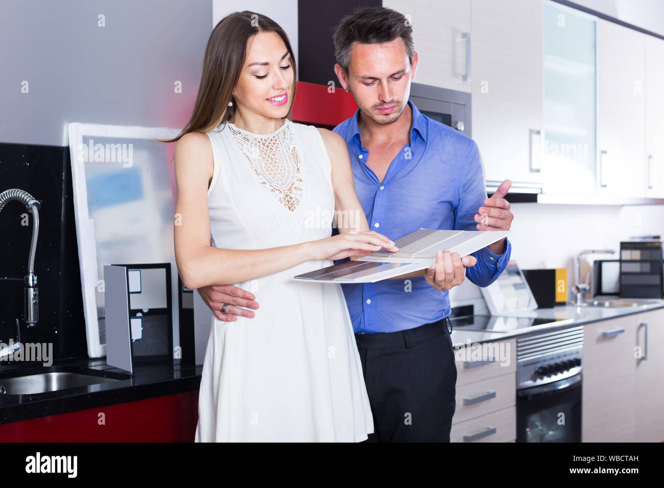 middle class positive family selecting modern kitchen furniture Stock ...