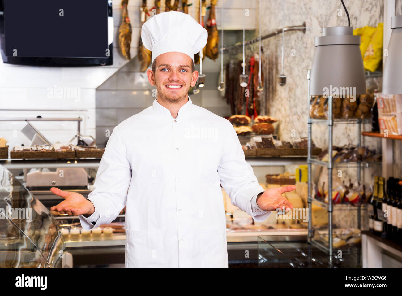 Happy male seller in his grocery shop welcoming customers Stock Photo ...