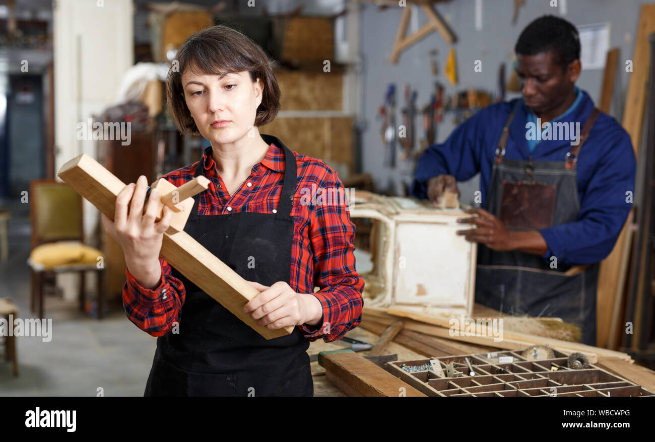Woman carpenter using tools for creating wooden furniture in studio ...