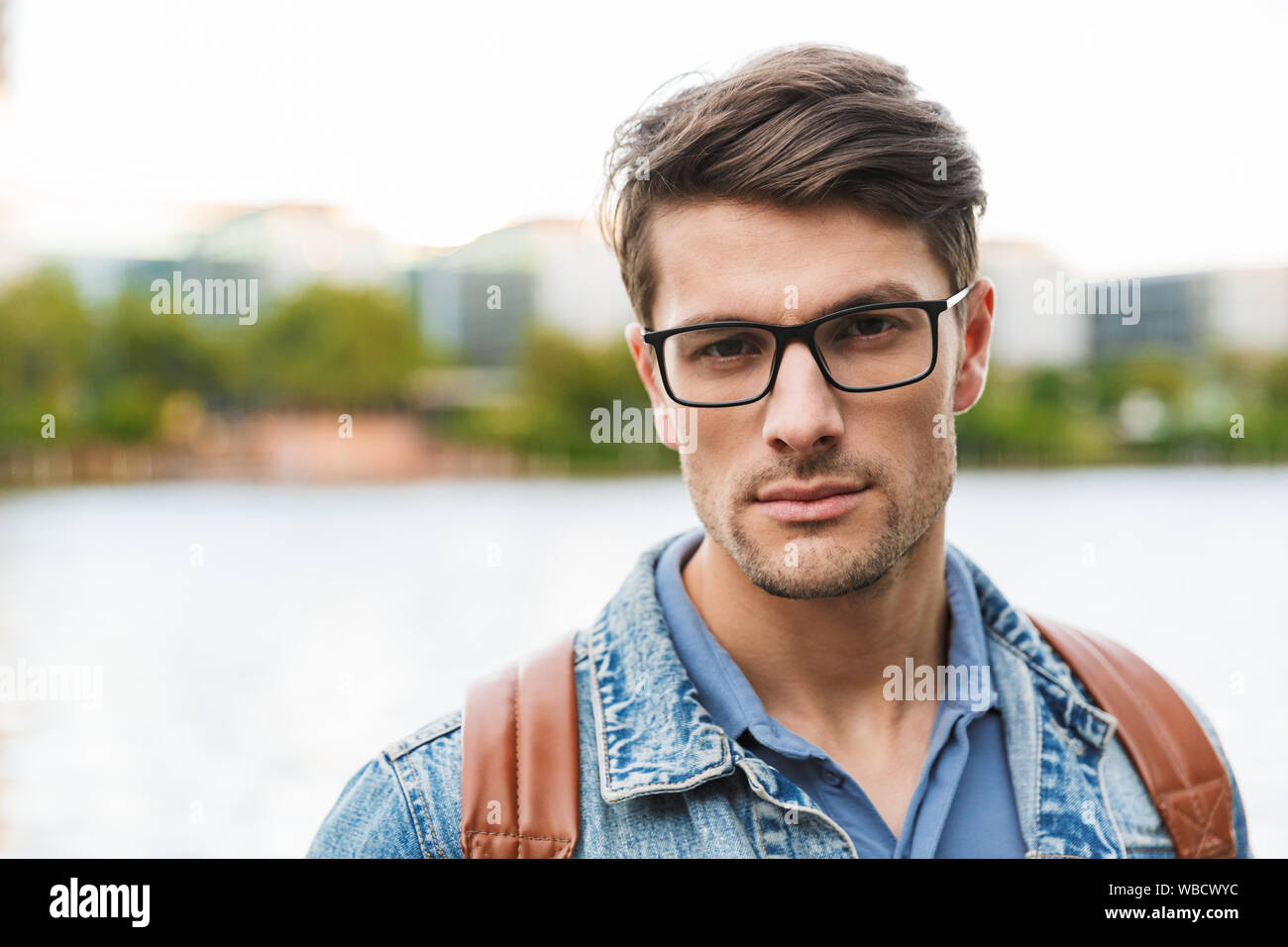 Handsome confident young man dressed casually spending time outdoors at ...