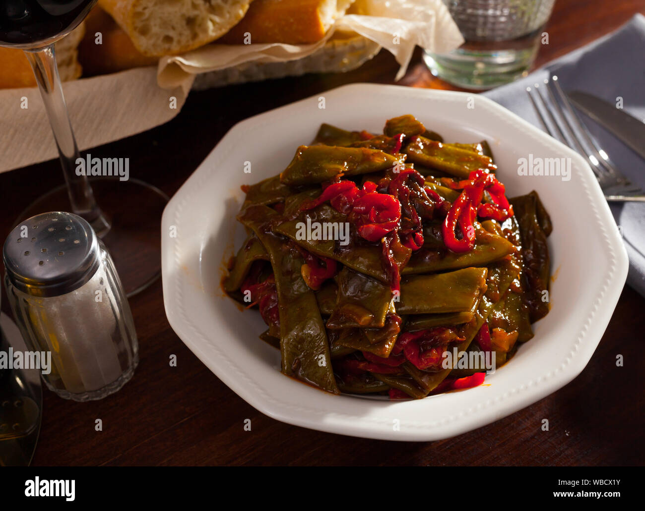 Appetizing string beans stewed with bell pepper on white plate served ...