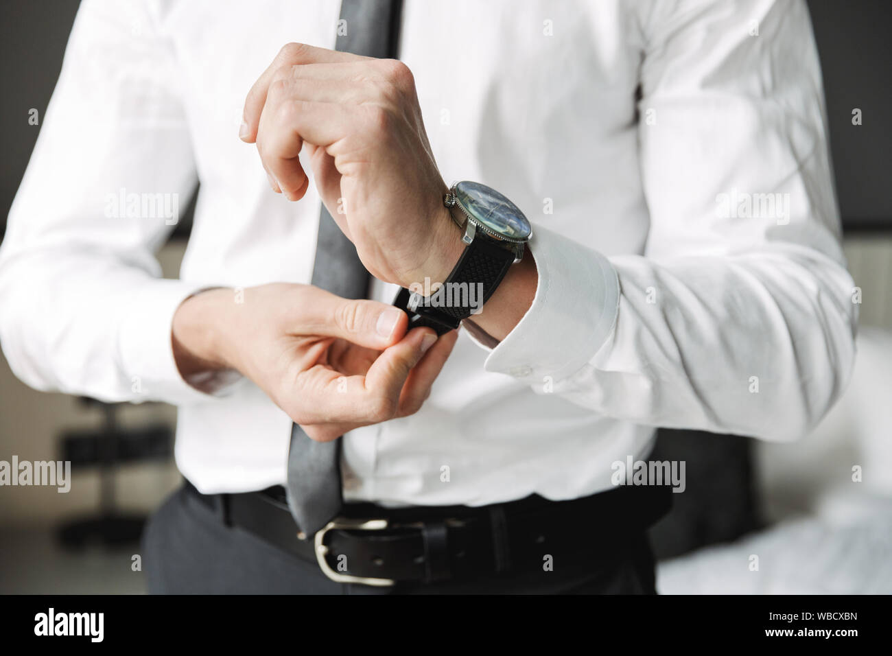 Cropped image of confident young man wearing formal suit taking off his ...