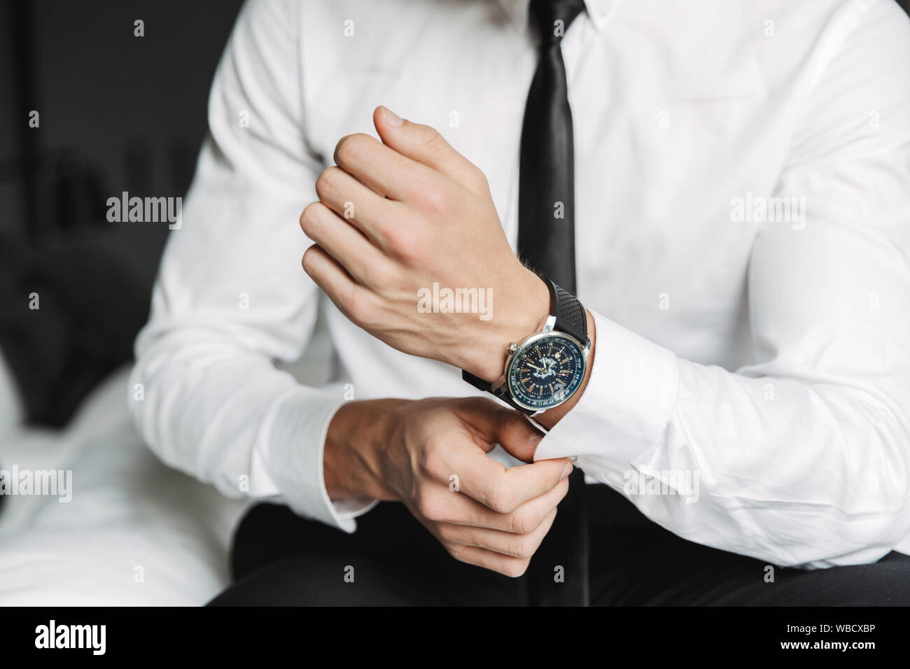 Cropped image of caucasian young man wearing formal suit taking off his ...