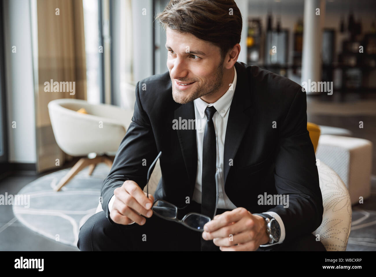 Photo of masculine businessman wearing formal black suit holding ...
