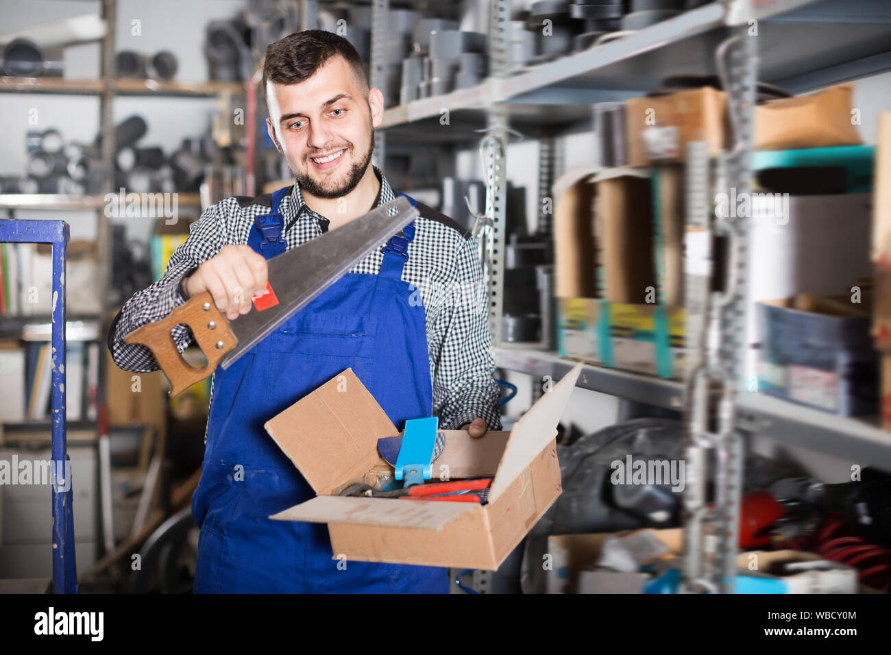 Smiling male worker showing his working tools at workshop Stock Photo ...