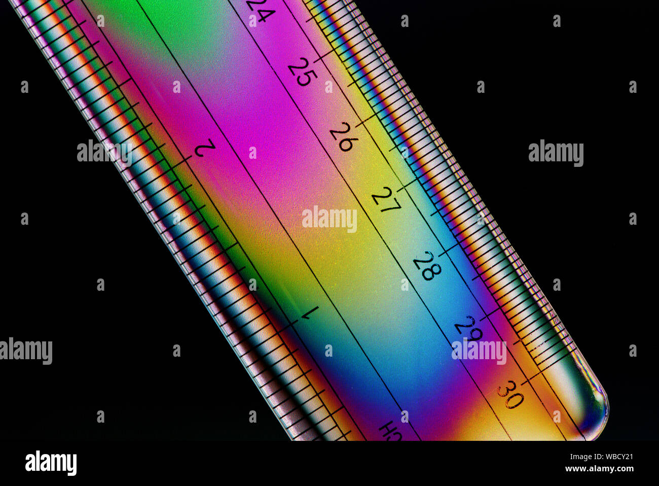 Cross polarised image of a ruler showing the colourful stress patterns ...