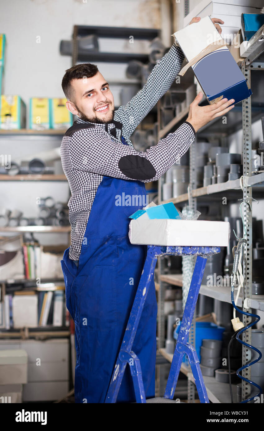 Young smiling male worker showing his workplace at workshop Stock Photo ...