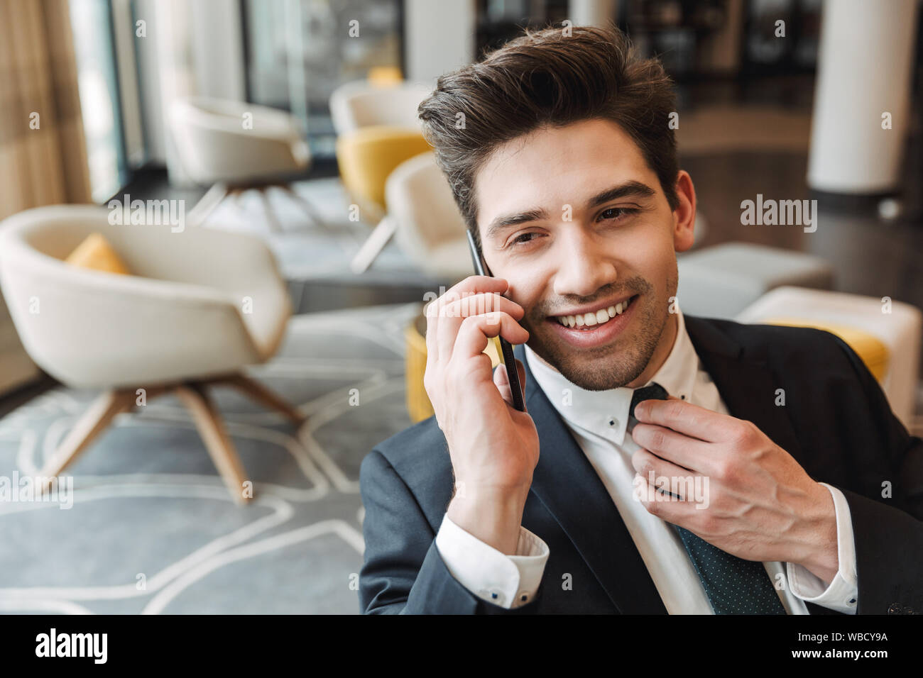 Photo of a young positive optimistic businessman indoors in business ...