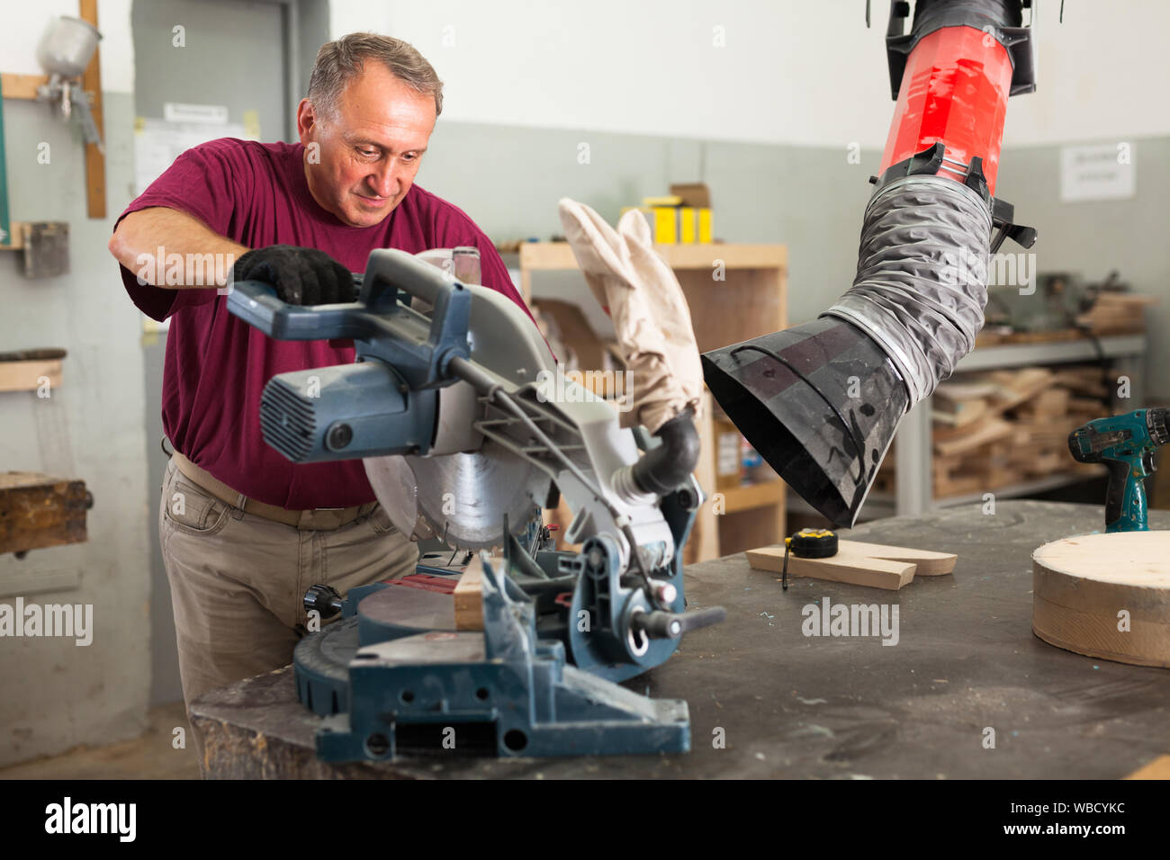 Confident workman cutting wooden planks using circular saw Stock Photo ...