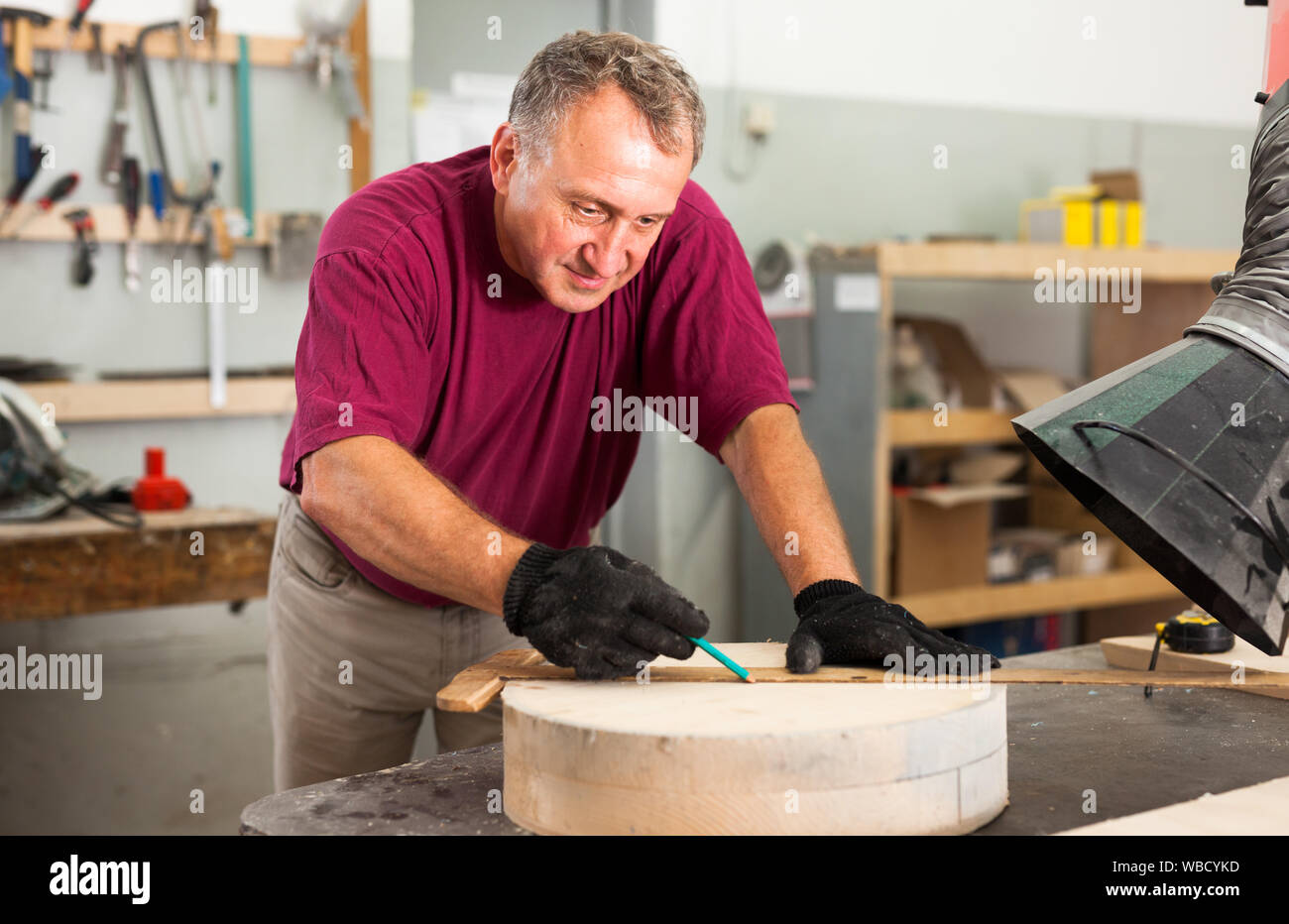 Worker performs measurements on wooden workpiece with caliper. Working ...