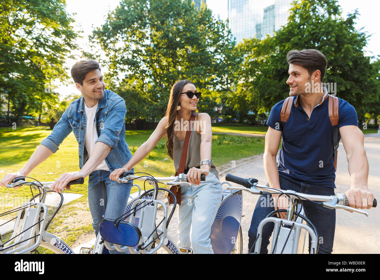 Group of happy cheerful friends riding bicycles at the park Stock Photo ...