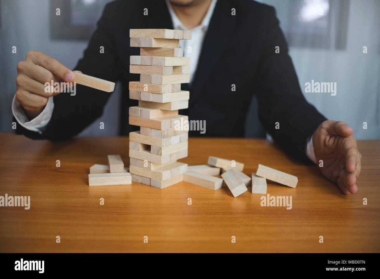 Businessmen picking wood blocks to fill the missing dominos and protect ...