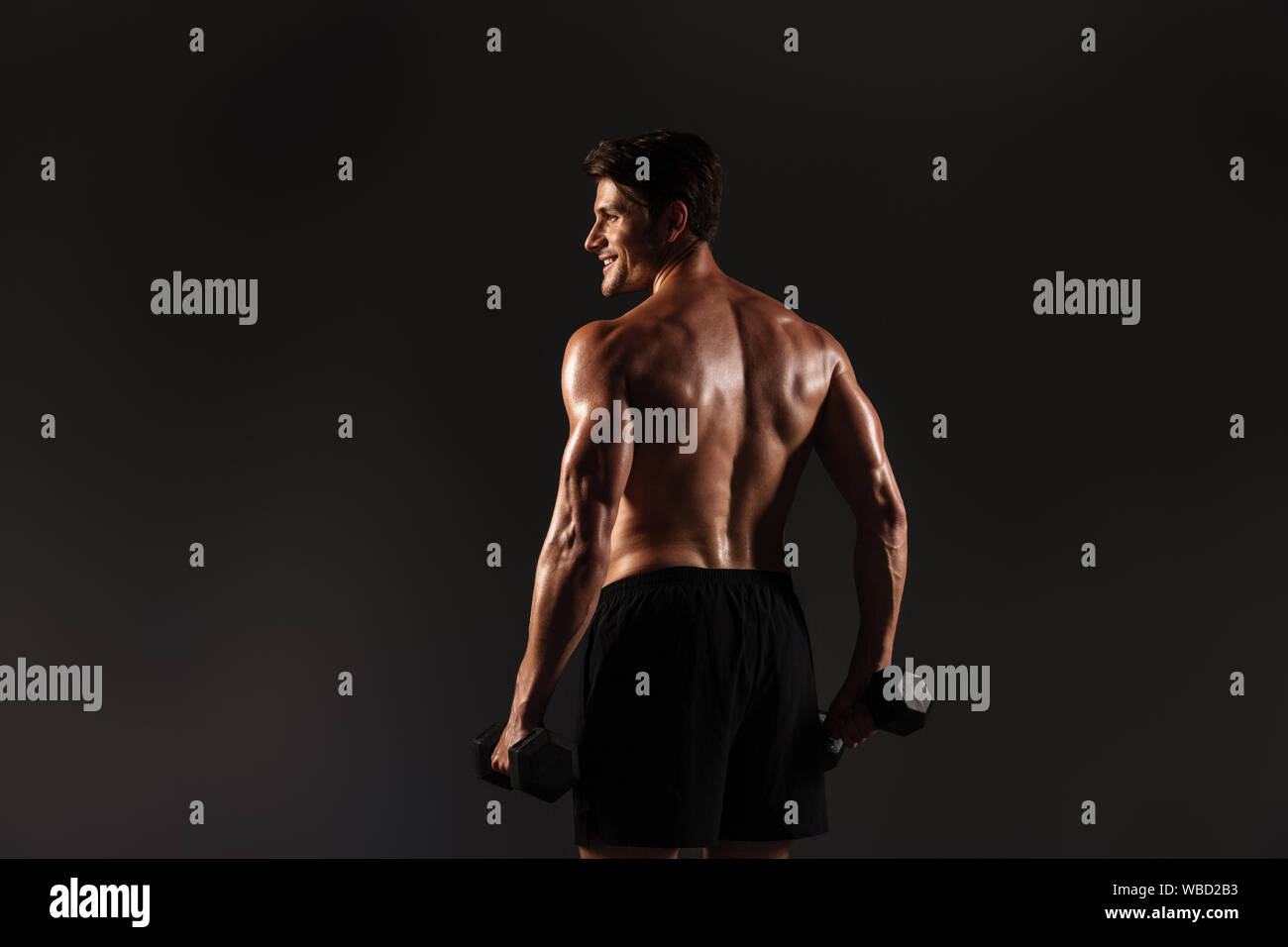 Back view photo of a handsome young strong sportsman posing isolated ...