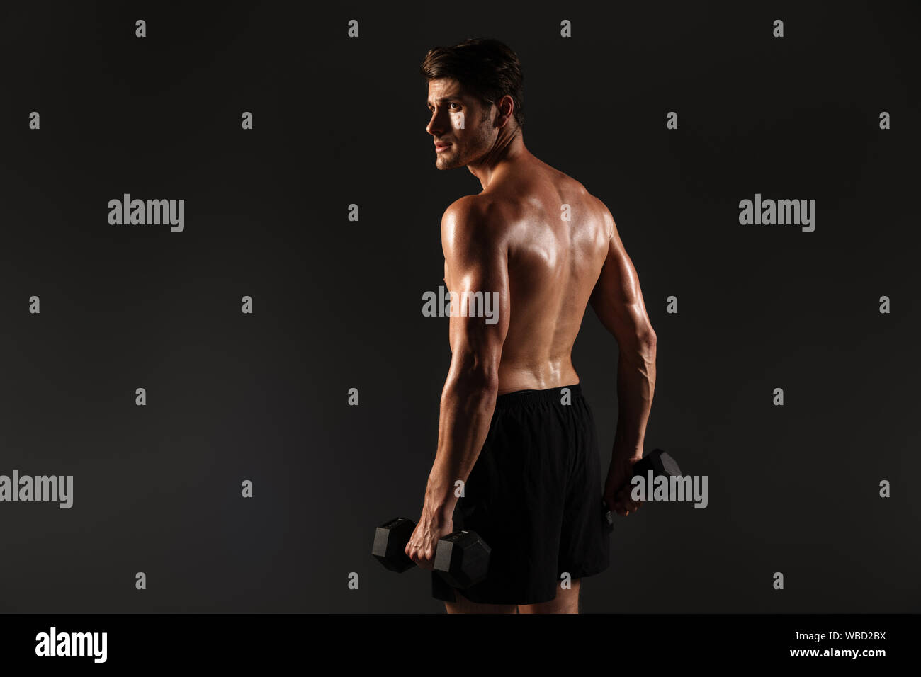 Back view photo of a handsome young strong sportsman posing isolated ...