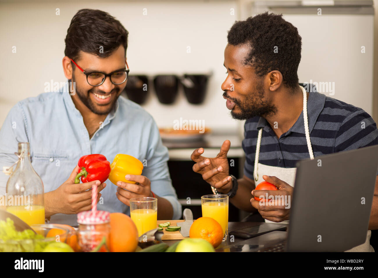Cheerful students cooking and having fun in kitchen. African american ...