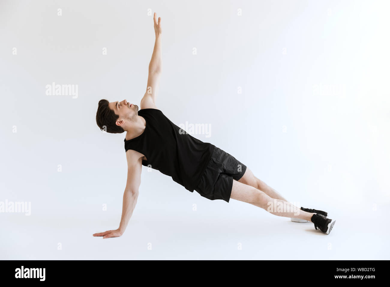 Attractive fit young sportsman doing plank exercises isolated over ...