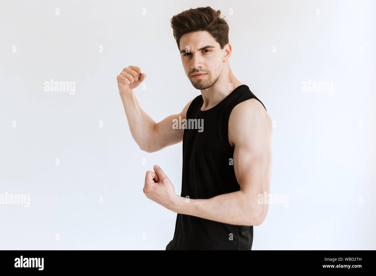 Image of a handsome young strong sports man posing isolated over white ...