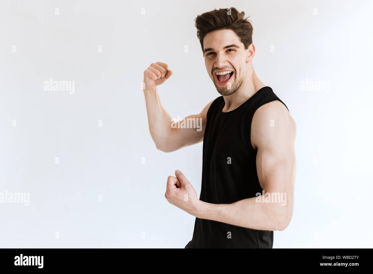 Image of a happy cheerful young strong sports man posing isolated over ...