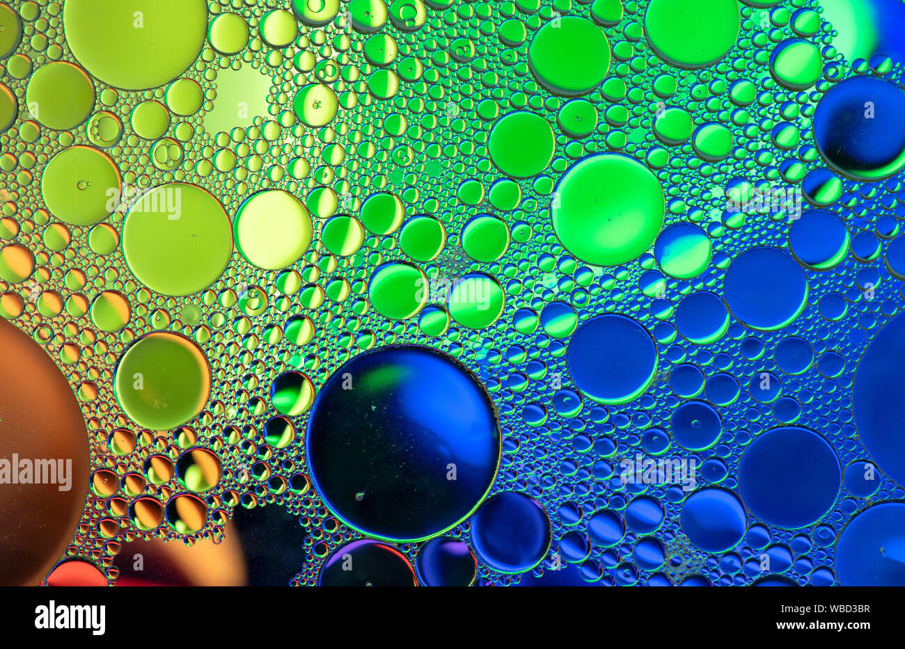 Multi-coloured bubble patterns formed by oil floating on water Stock ...