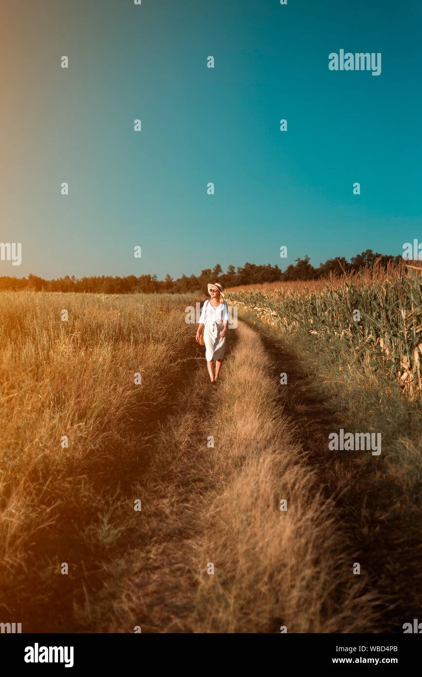 Woman walking on rural road hi-res stock photography and images - Alamy