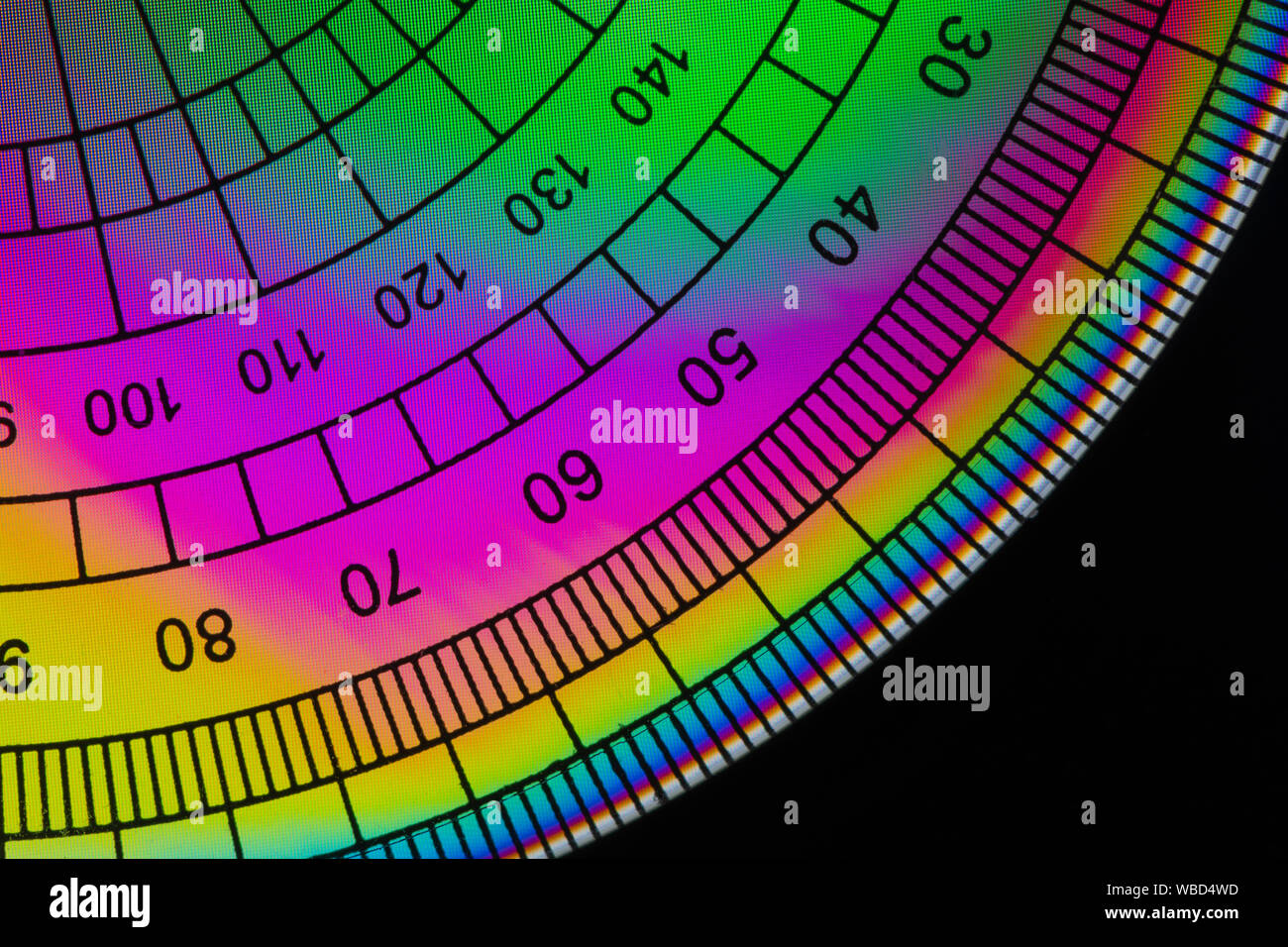 Cross polarised image of a geometry protractor showing the colourful ...