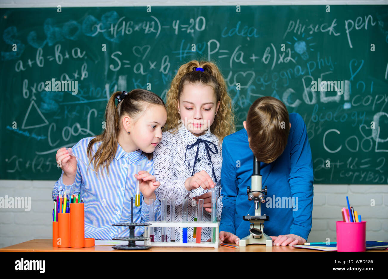 students doing biology experiments with microscope. Little kids ...
