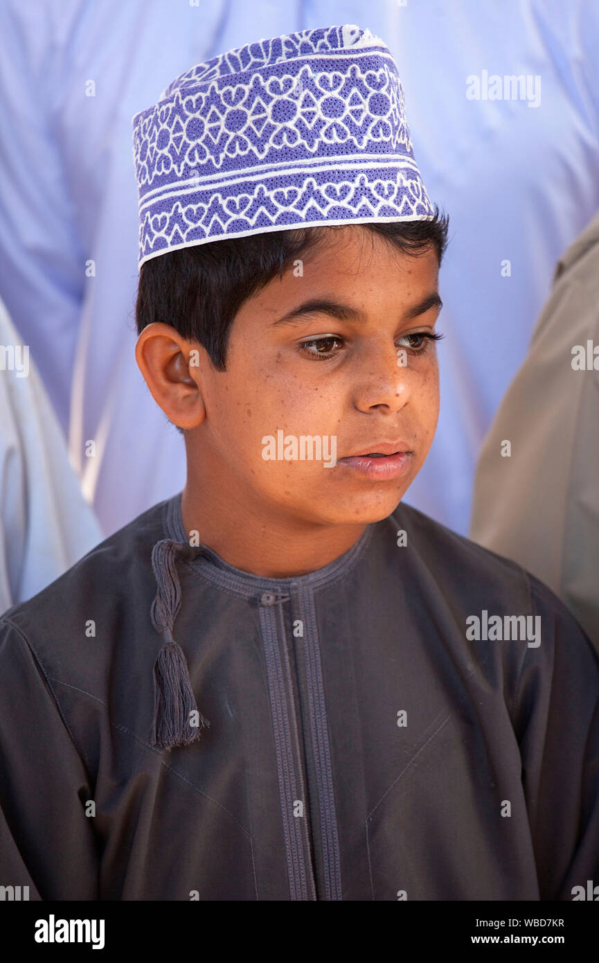 Portrait of young boy in traditional clothing wearing embroidered cap ...