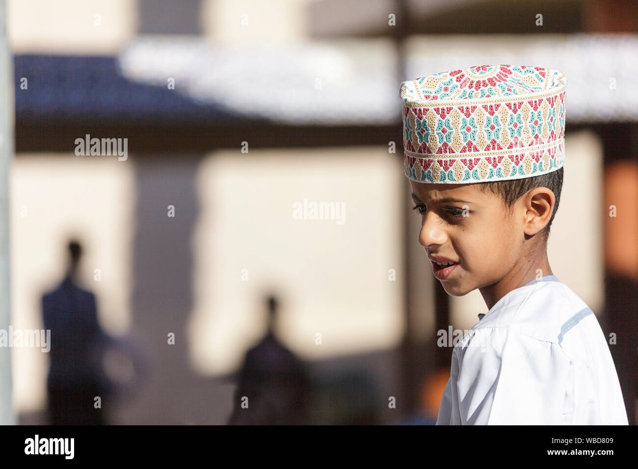 Portrait of young boy in traditional clothing wearing embroidered cap ...
