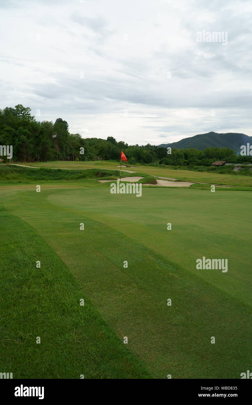 Red flag and green grass sand bunker at the beautiful golf course at ...