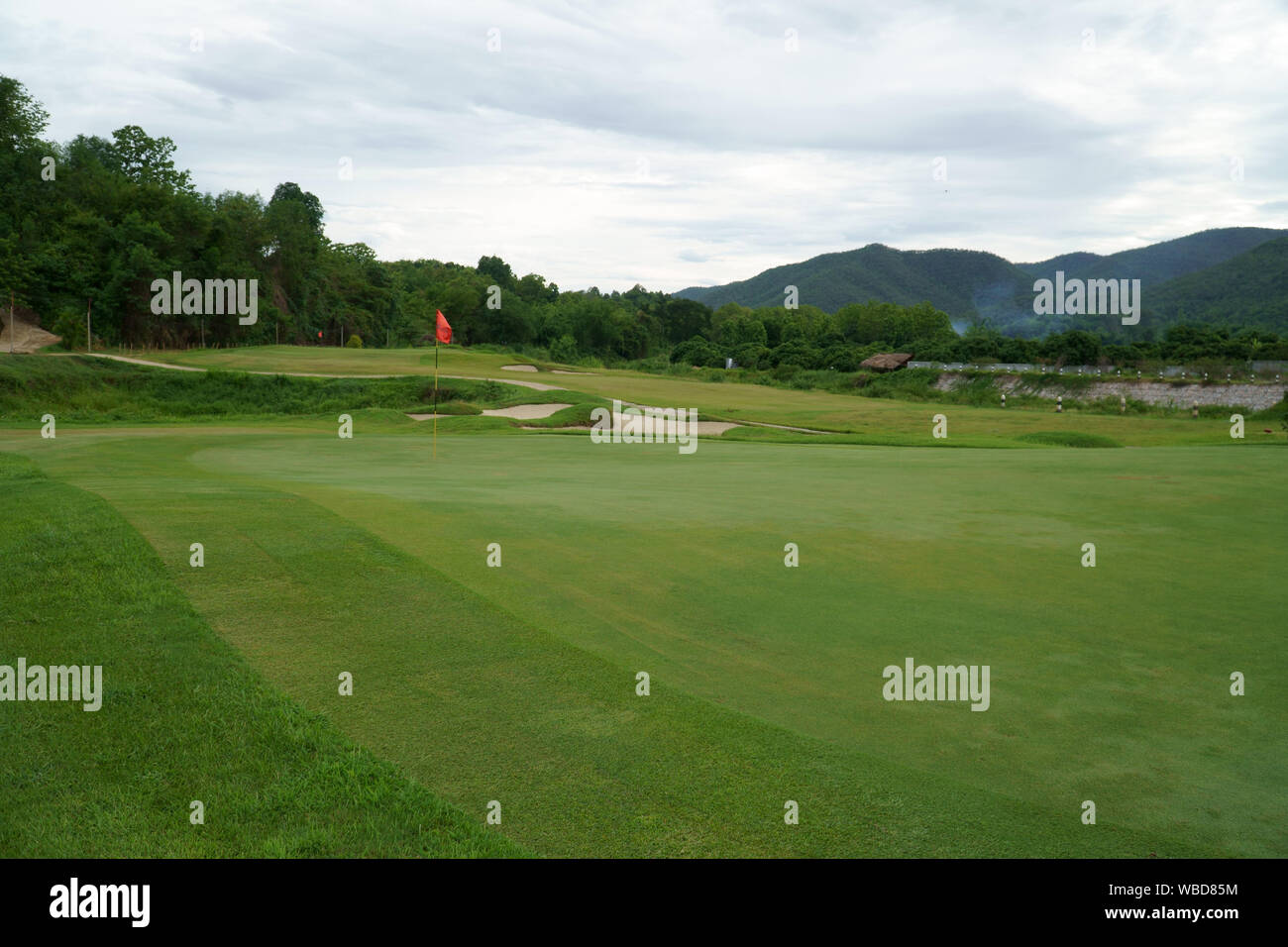Red flag and sand bunker at the beautiful golf course at the mountain ...